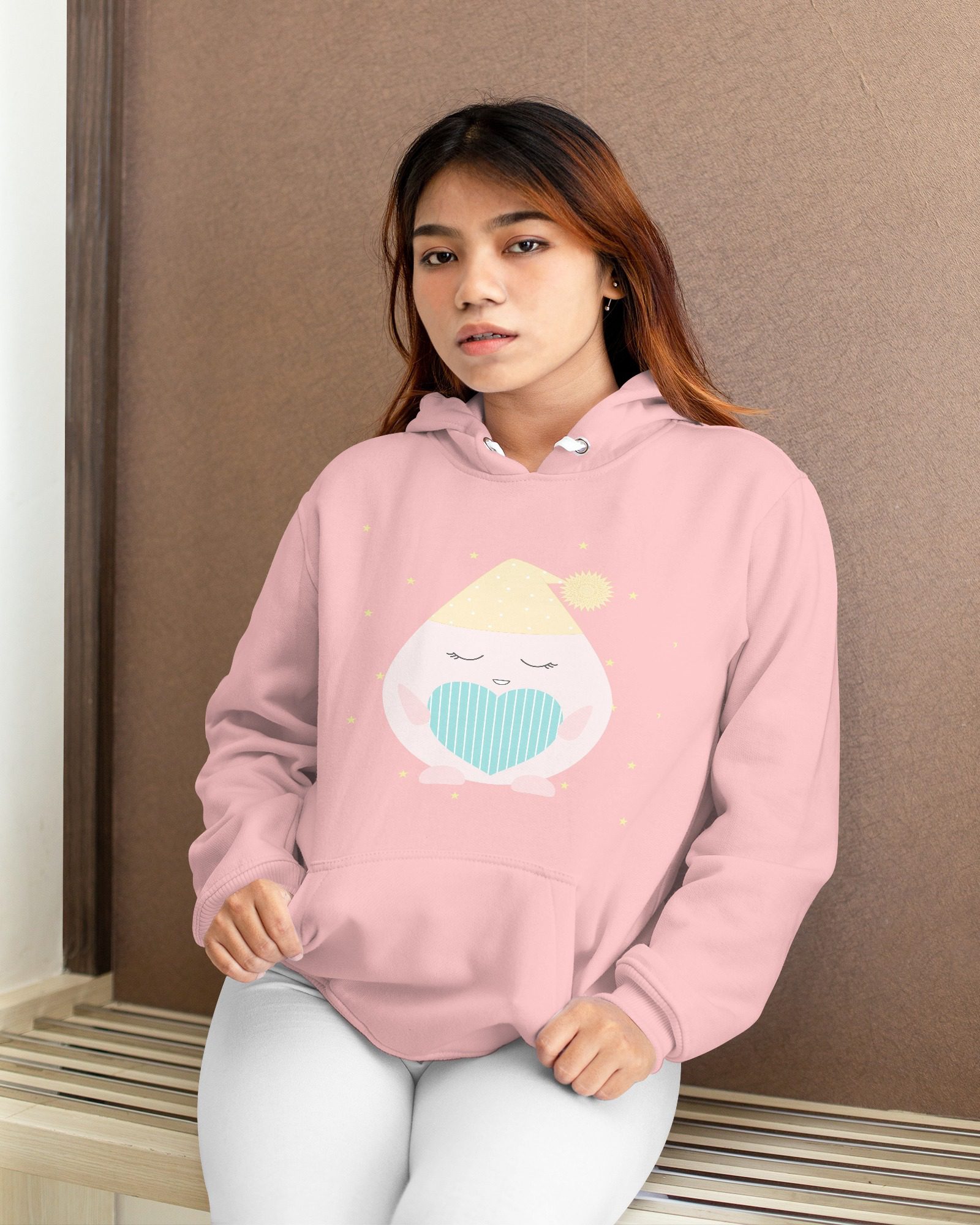 Young Woman Posing Her Hoodie Mockup with Cute Design | Mediamodifier